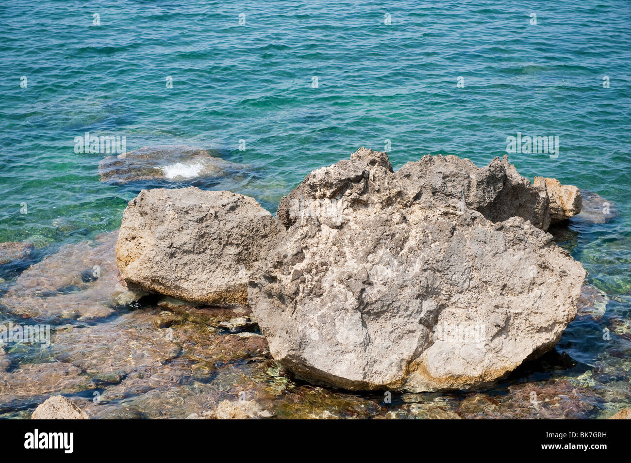 Calm coast with sea water and rocks Stock Photo - Alamy
