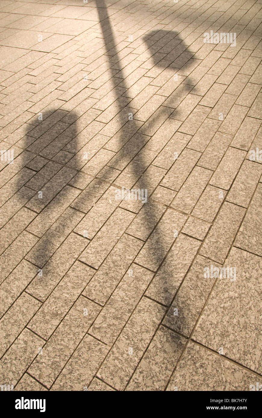 shadow of an old fashioned ornamental street lamp on the pavement or ...