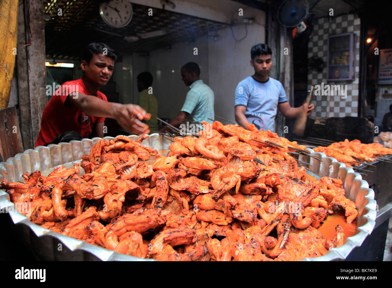 Two tandoor-wallah boys cook tandoori chicken at a street stall in the ...
