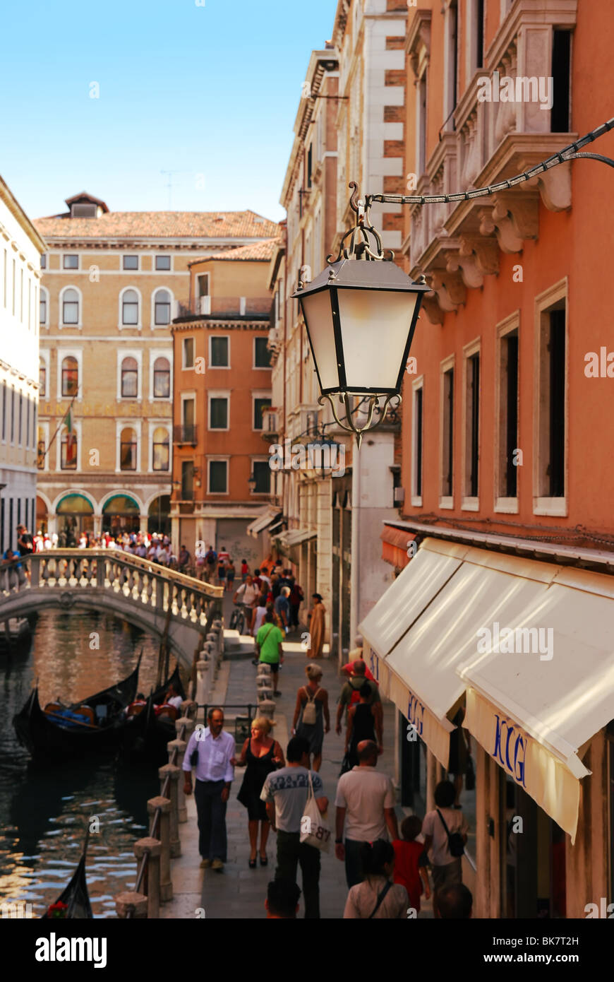 Tourists walking down Venice street with shops, restaurants Stock Photo ...