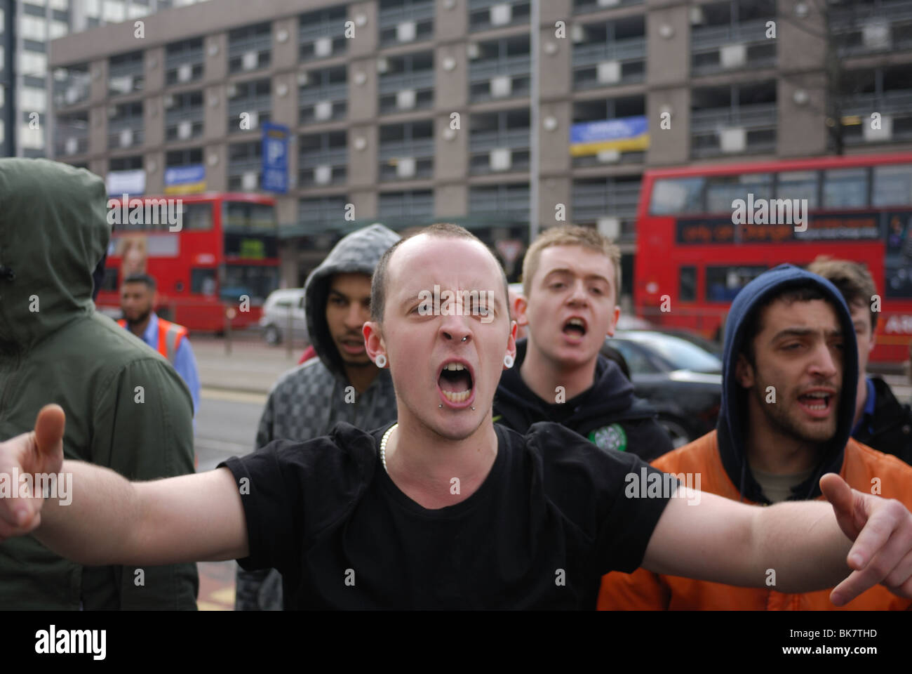 An angry Unite Against Fascism protester shouts 'Nazi scum' at BNP ...