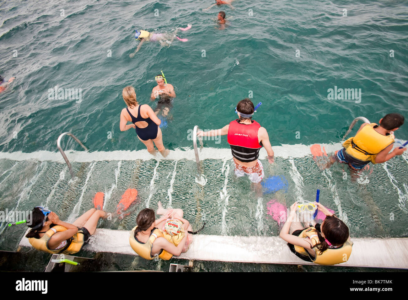 Tourists snorkelling from a dive and snorkel platform anchored to the ...