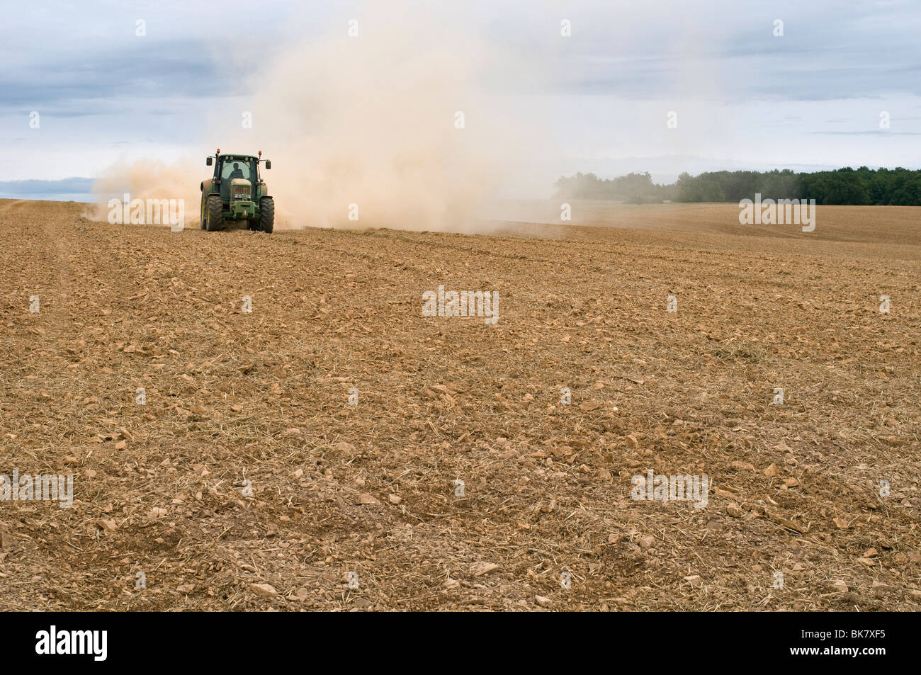 Tractor crushing stone in a field Stock Photo - Alamy