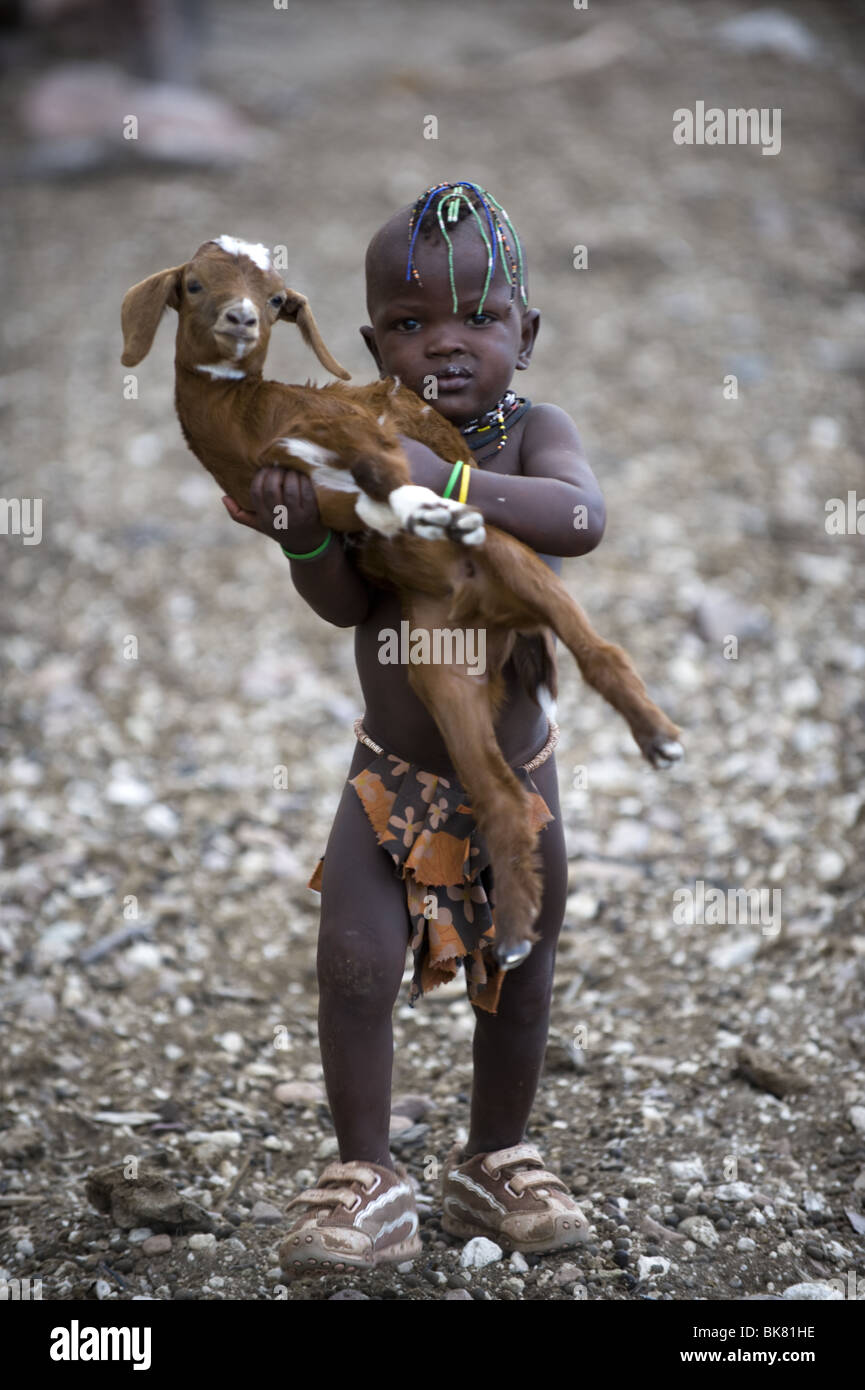 Himba child carrying a baby goat, Kaokoland, Namibia Stock Photo - Alamy