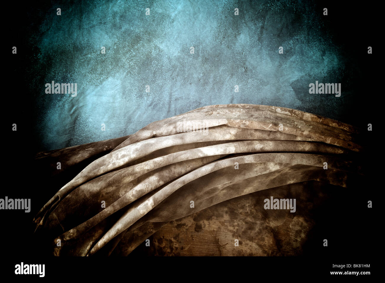 a gray mottled backdrop is draped over a blue mottled backdrop cloth ...