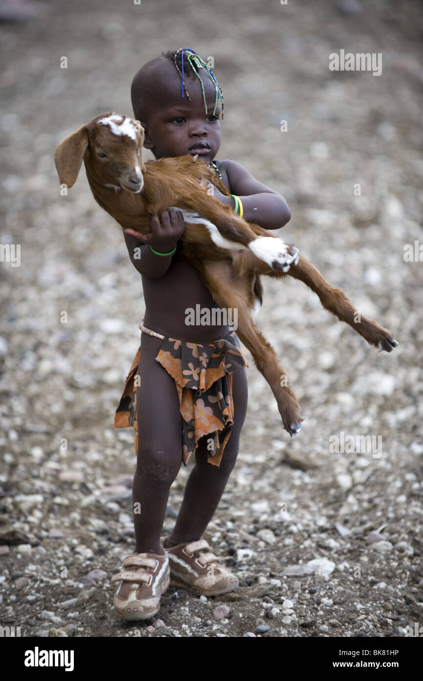 Himba child carrying a baby goat, Kaokoland, Namibia Stock Photo - Alamy