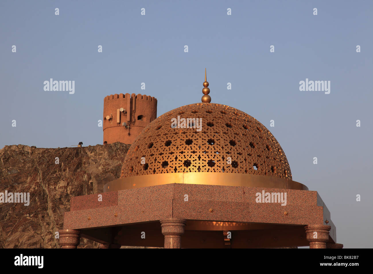 golden dome of sun shelter building and fortified tower at Muscat ...