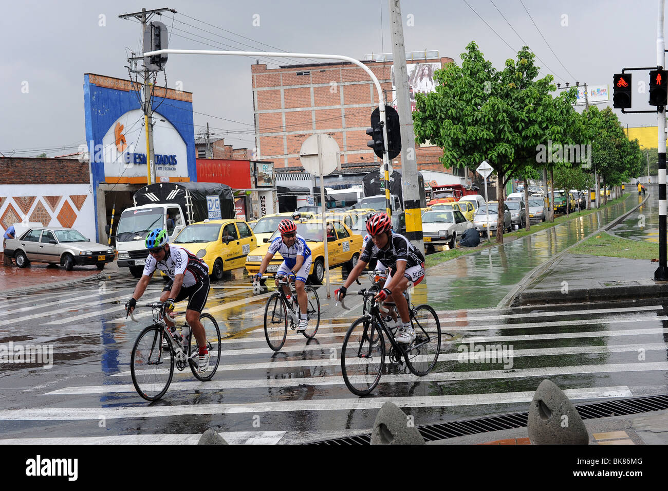 Three cyclists in the rain. Medellin, Colombia Stock Photo - Alamy