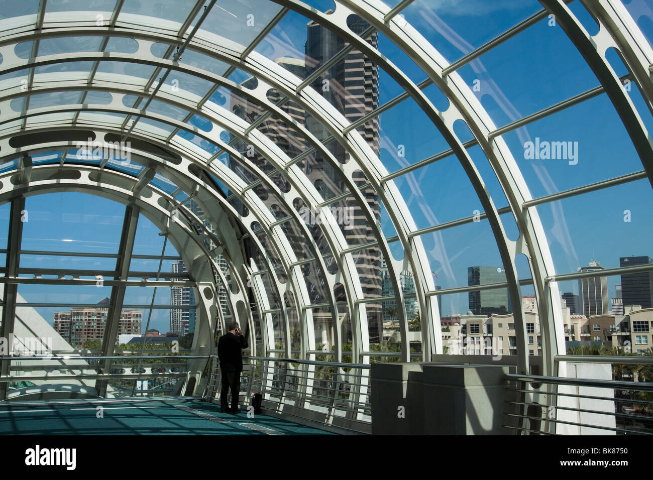 Business man making phone call in hallway with curved glass ceiling in ...