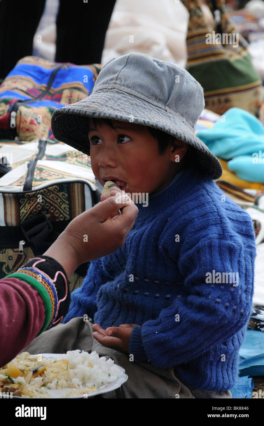 Child being fed at a market, Chinchero, Inca settlement, Quechua ...