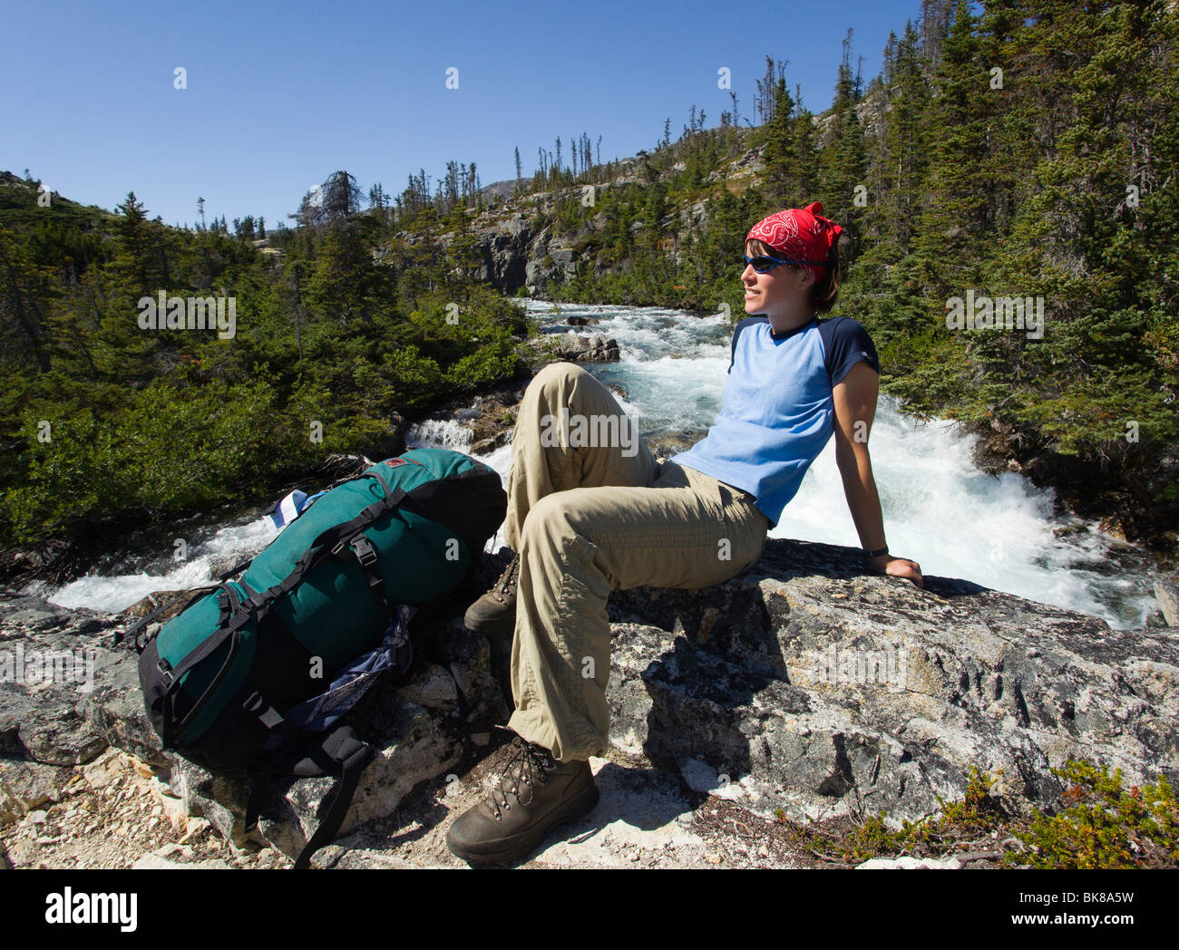 Young woman, hiker, backpacker, backpack, sitting on rock, resting ...