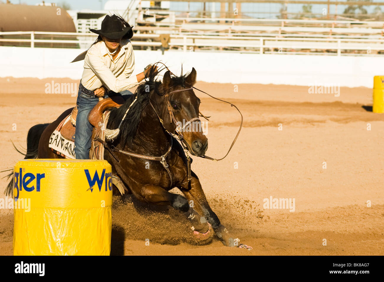 a cowgirl competes in the barrel racing event at a rodeo Stock Photo ...