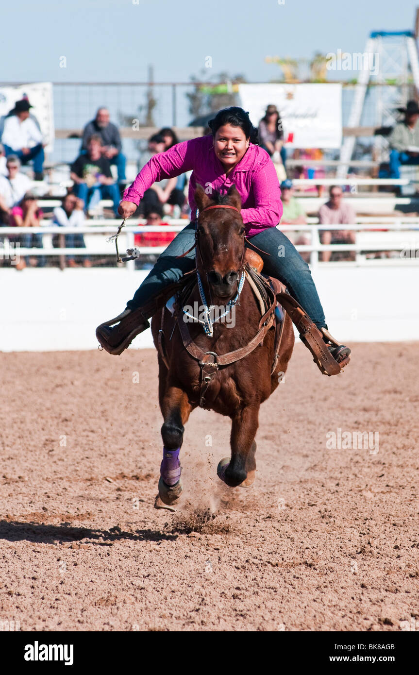 a cowgirl competes in the barrel racing event at a rodeo Stock Photo ...