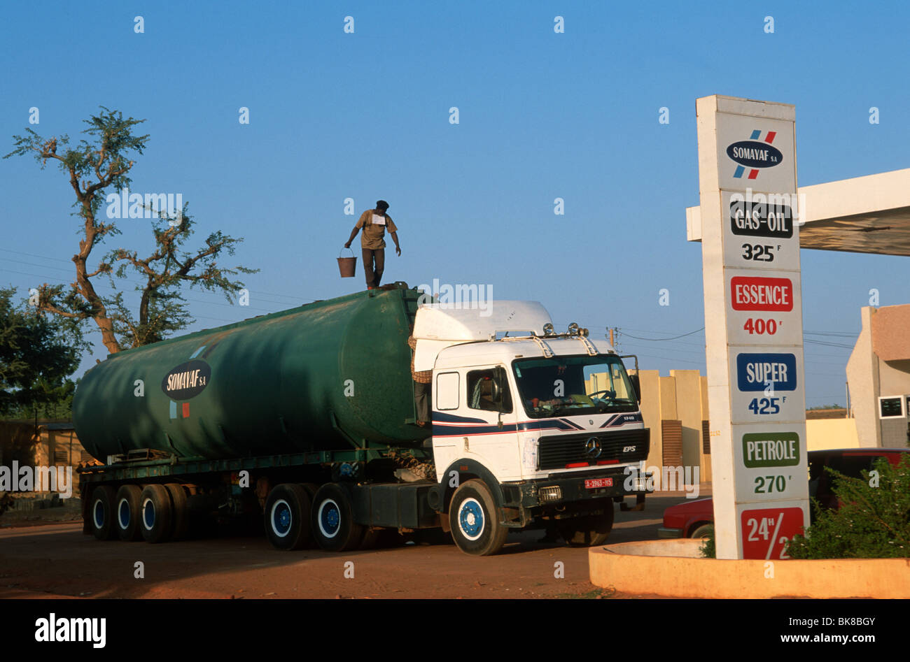 A gasoline/petrol/motor fuel tanker filling fuel tanks at a filling ...