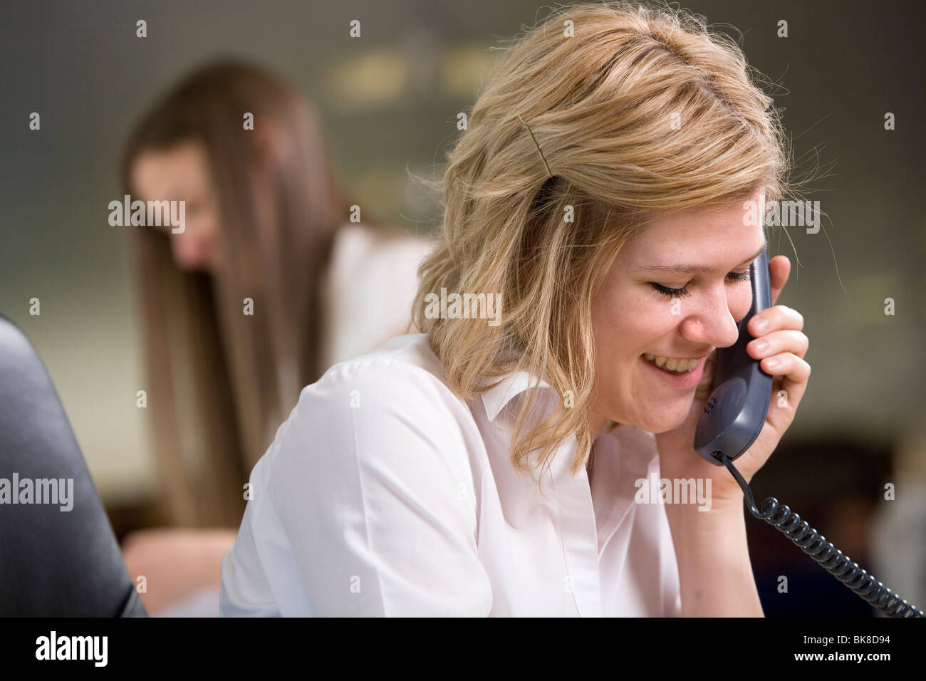 Happy secretary takes a phone call in the office Stock Photo - Alamy