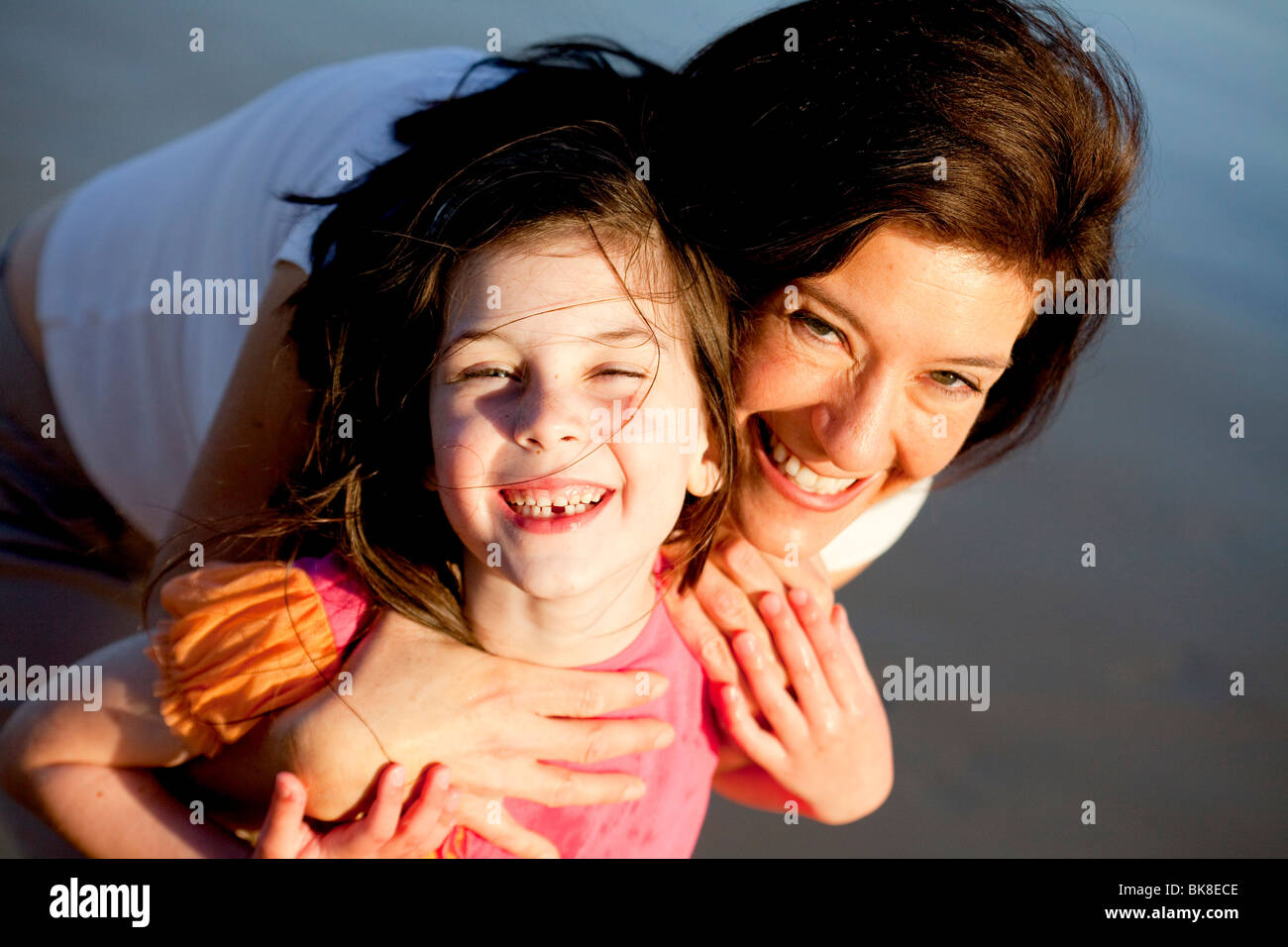 mother and daughter smile at beach Stock Photo - Alamy