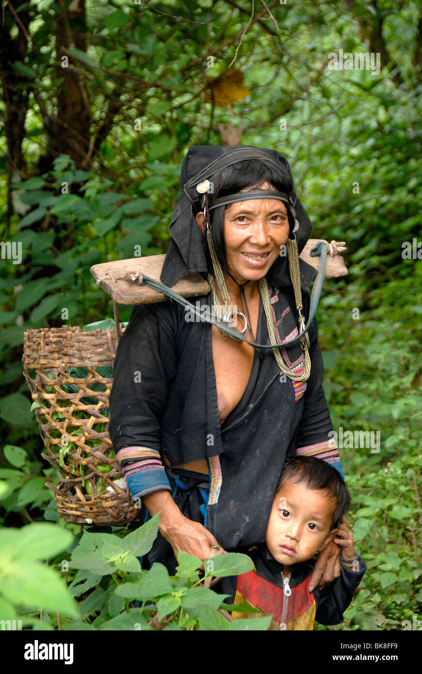 Women of the Akha Pixor ethnic group with child smiling and carrying a ...