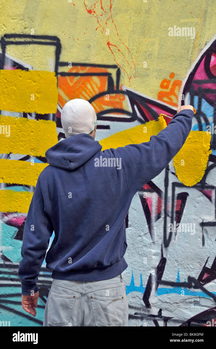 Graffiti artist working on a graffiti-covered wall, Cologne, North ...