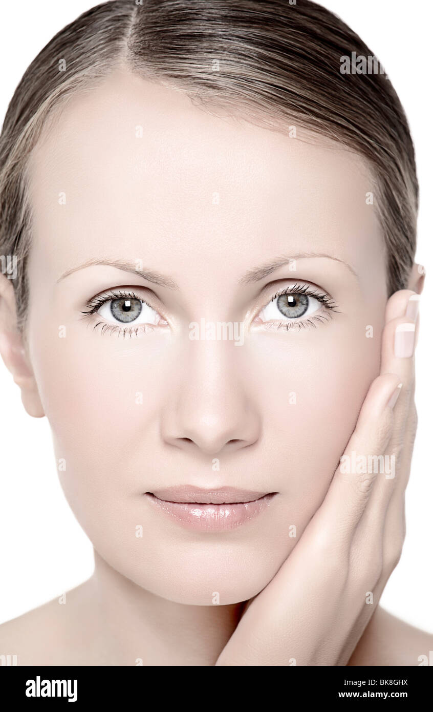 Young woman touching her cheek with her hand Stock Photo - Alamy