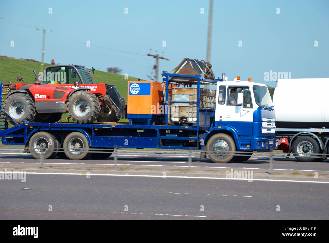 Digger on a flatbed lorry Stock Photo - Alamy