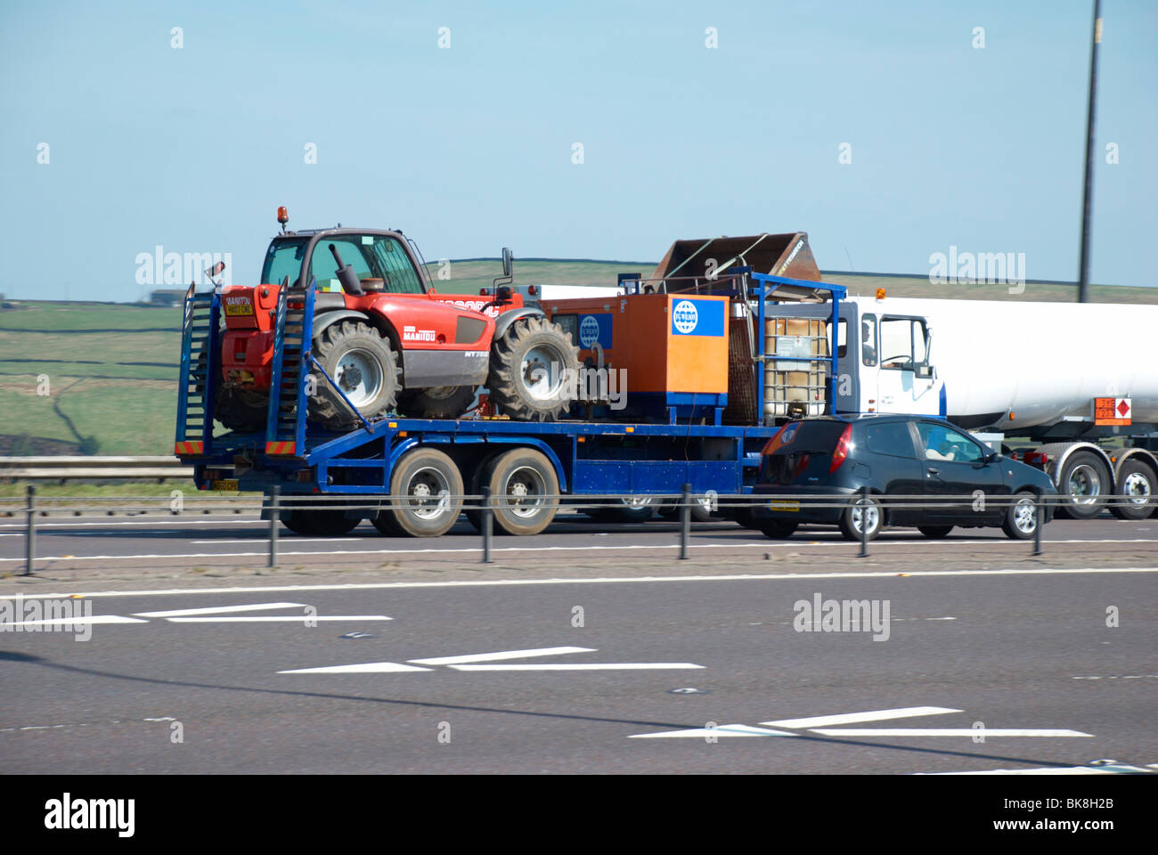 Digger on a flatbed lorry Stock Photo - Alamy
