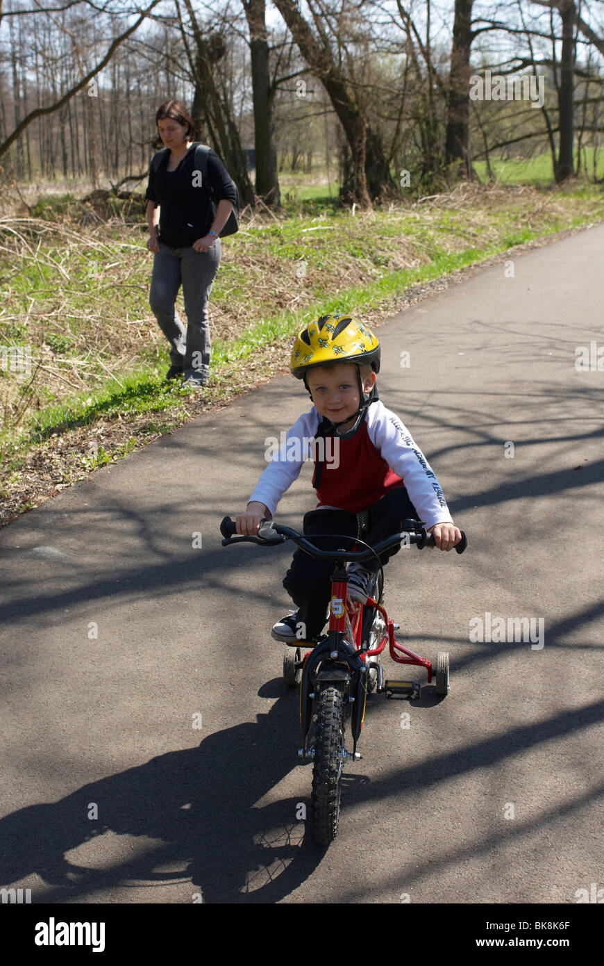 Boy Learning to Ride Bicycle with stabilizing wheel bike Stock Photo ...