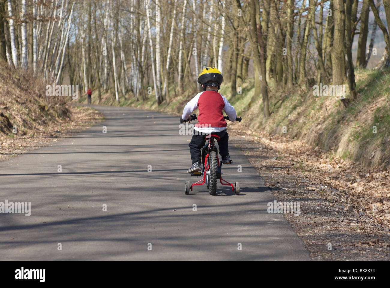 Boy Learning to Ride Bicycle with stabilizing wheel bike Stock Photo ...