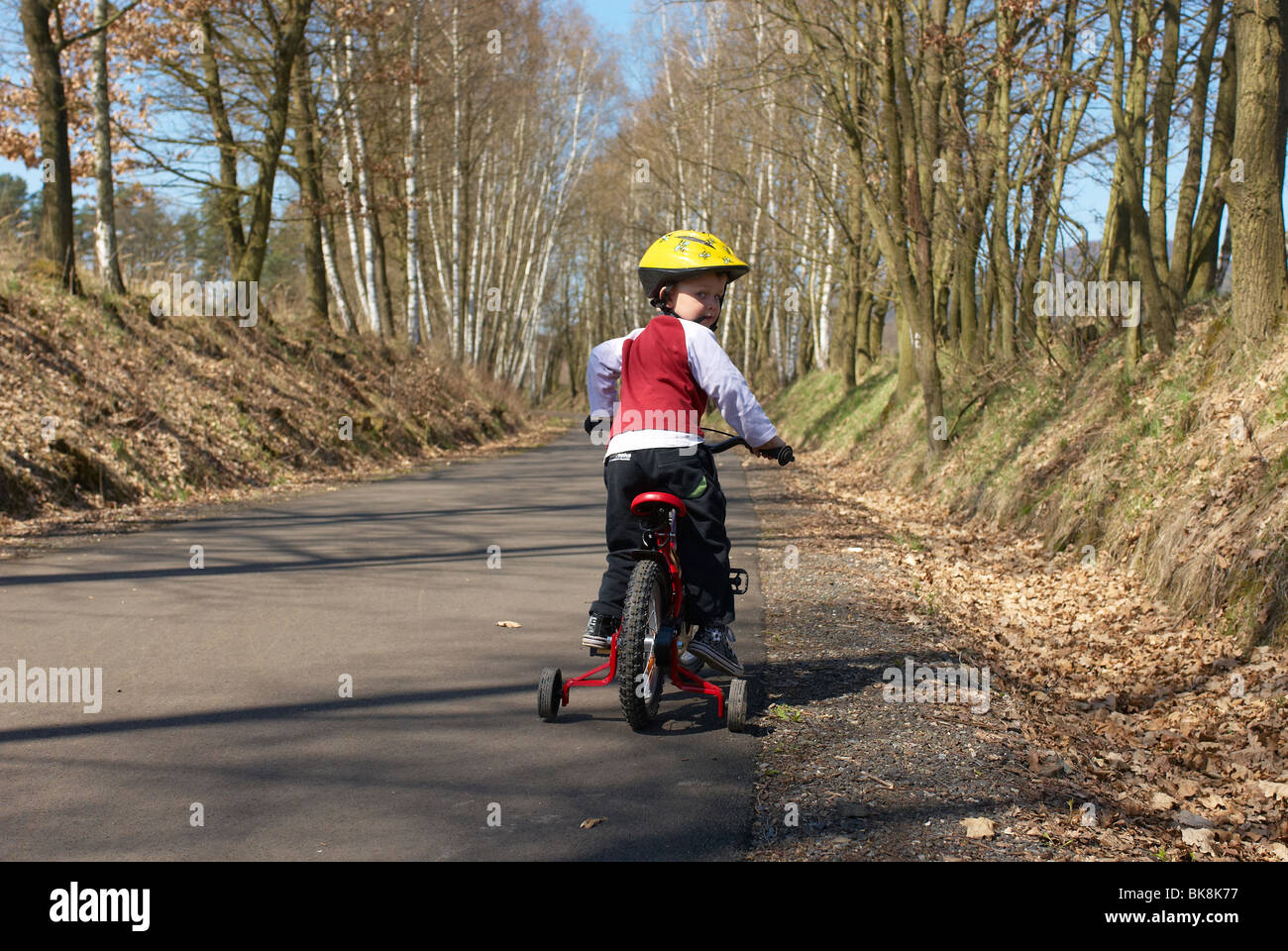 Boy Learning to Ride Bicycle with stabilizing wheel bike Stock Photo ...