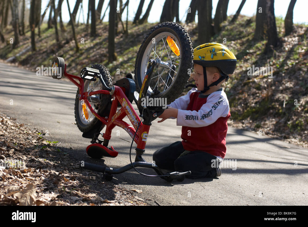 Boy Learning to Ride Bicycle with stabilizing wheel bike Stock Photo ...