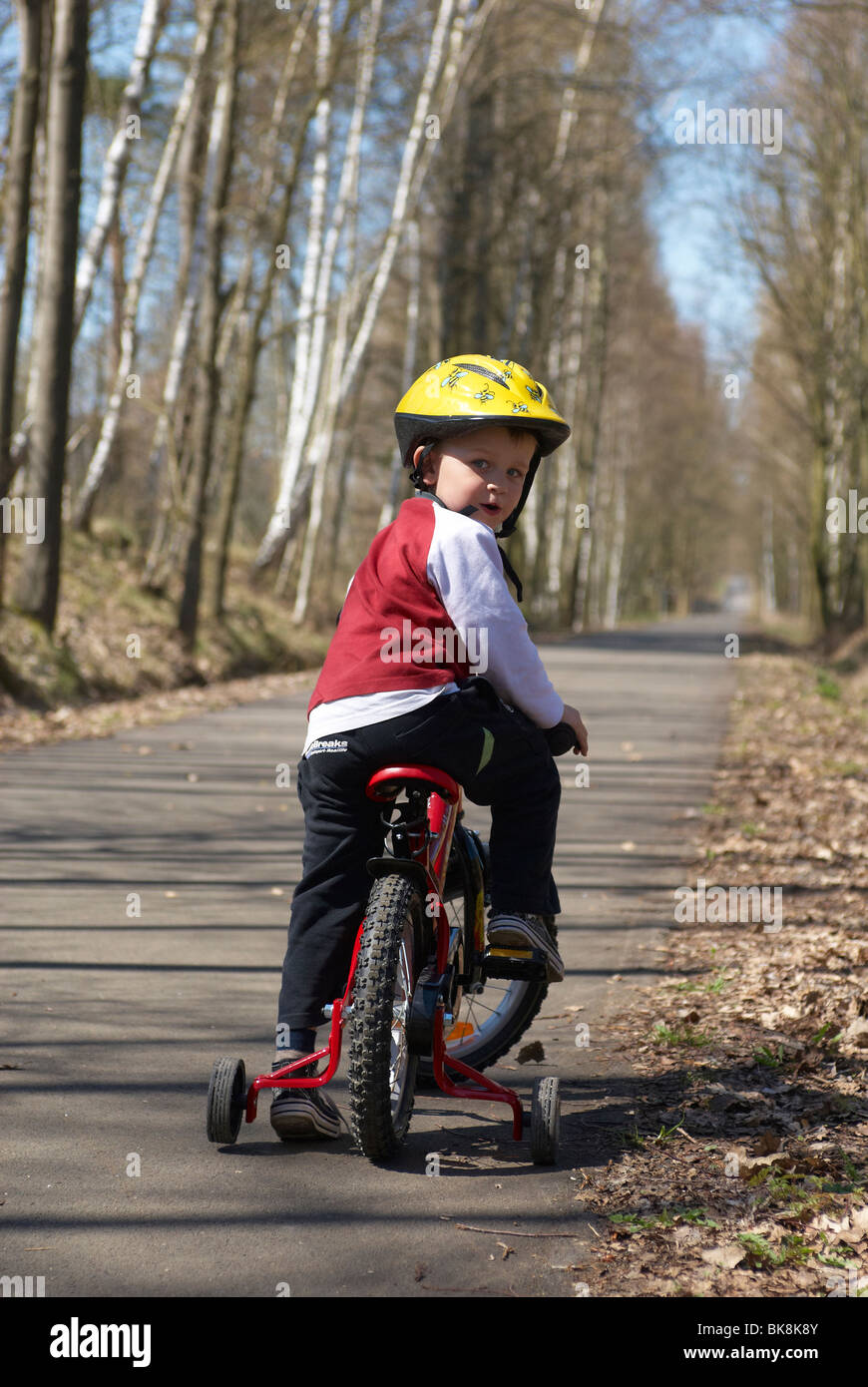 Boy Learning to Ride Bicycle with stabilizing wheel bike Stock Photo ...