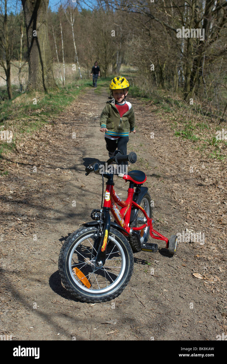 Boy Learning to Ride Bicycle with stabilizing wheel bike Stock Photo ...