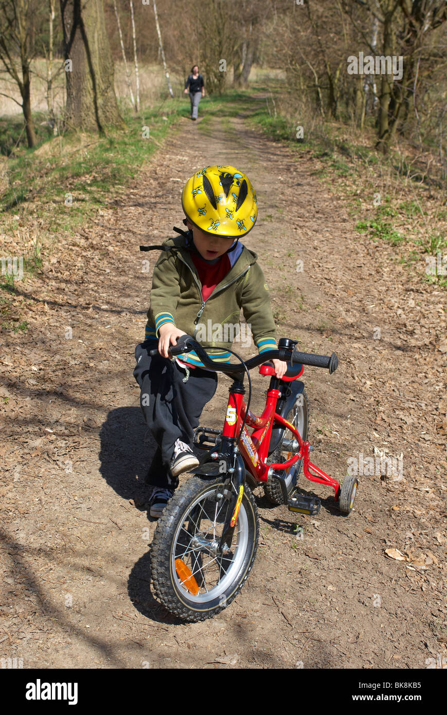 Boy Learning to Ride Bicycle with stabilizing wheel bike Stock Photo ...