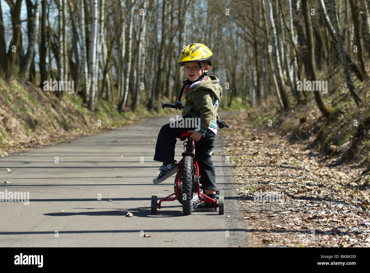 Boy Learning to Ride Bicycle with stabilizing wheel bike Stock Photo ...