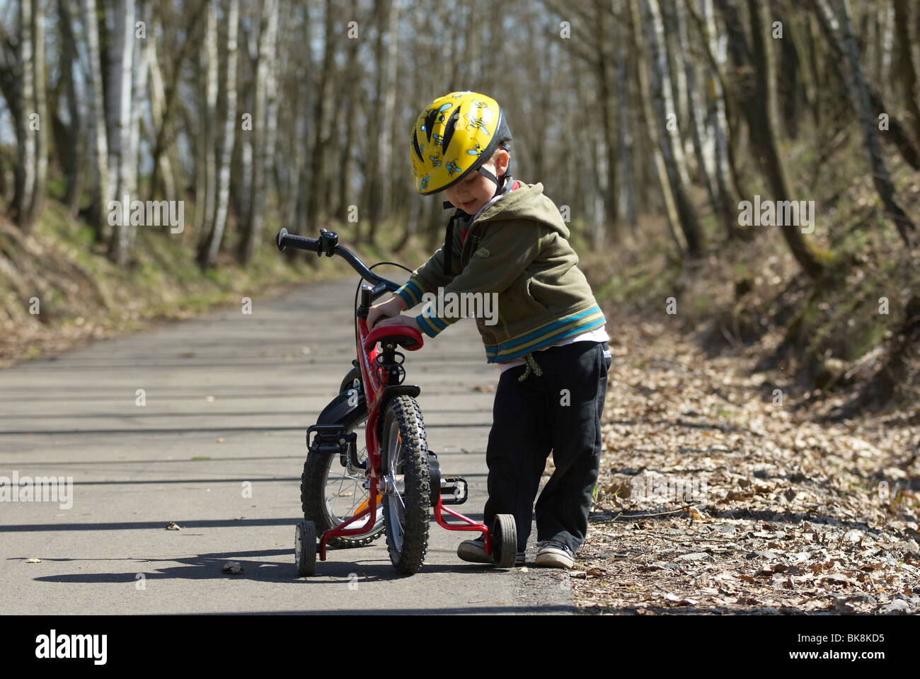 Boy Learning to Ride Bicycle with stabilizing wheel bike Stock Photo ...