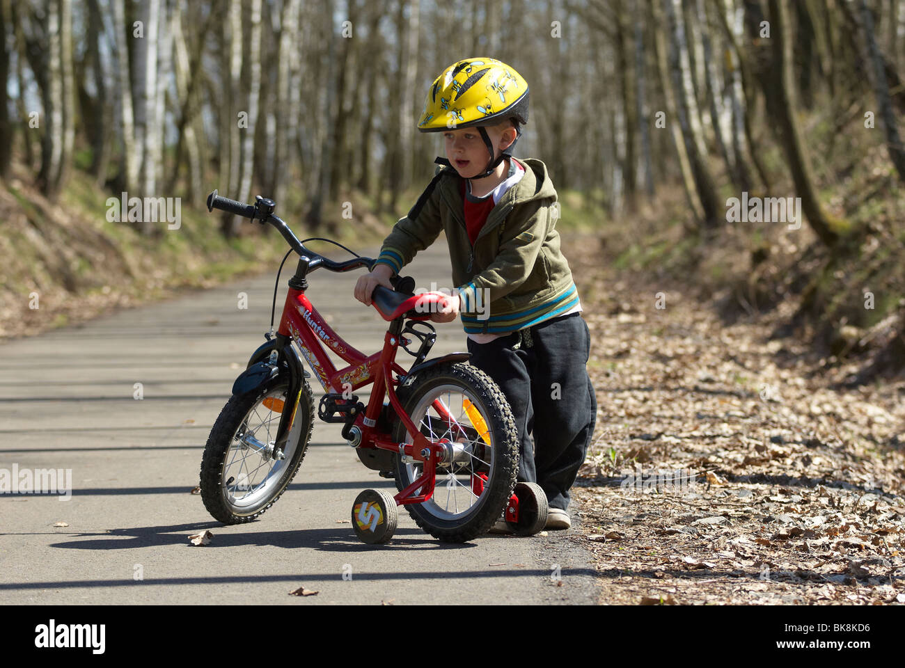 Boy Learning to Ride Bicycle with stabilizing wheel bike Stock Photo ...