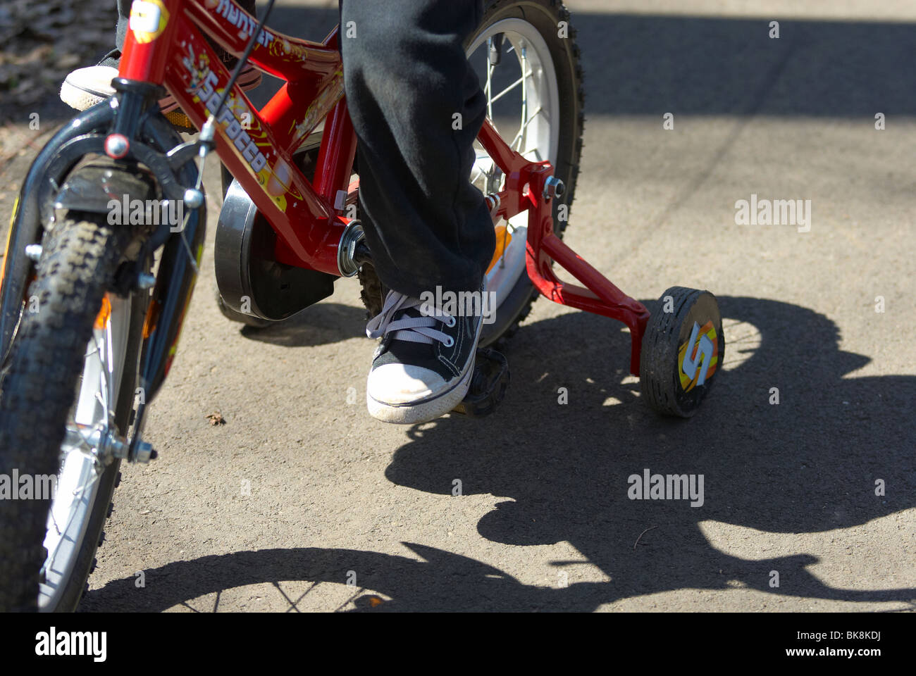 Boy Learning to Ride Bicycle with stabilizing wheel bike Stock Photo ...