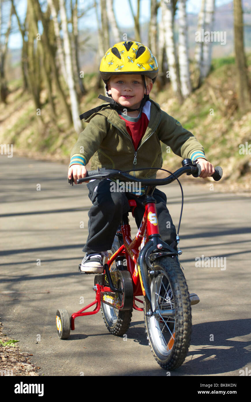 Boy Learning to Ride Bicycle with stabilizing wheel bike Stock Photo ...