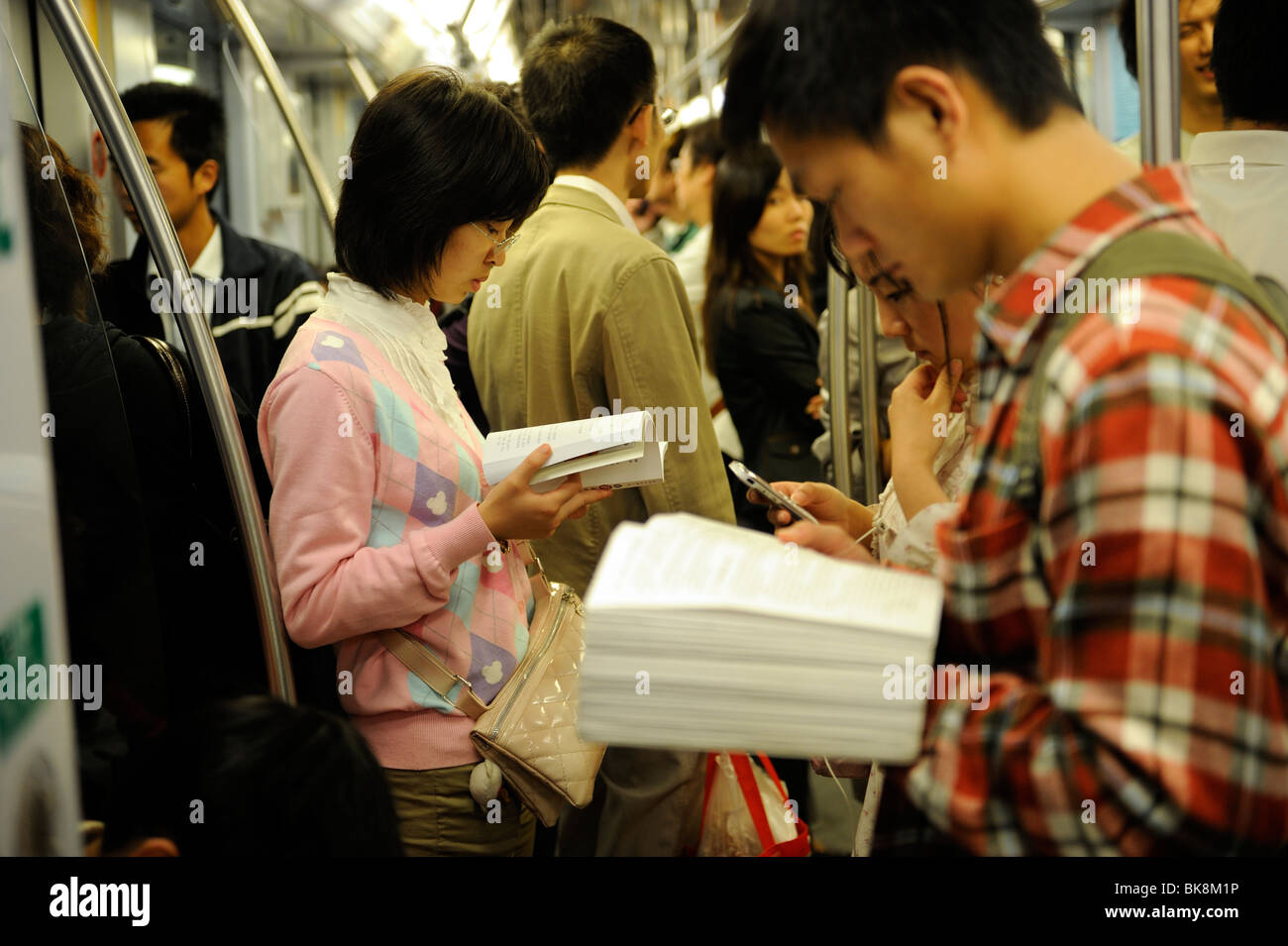 Passengers reading books on a light rail train in Shanghai, China. 21 ...
