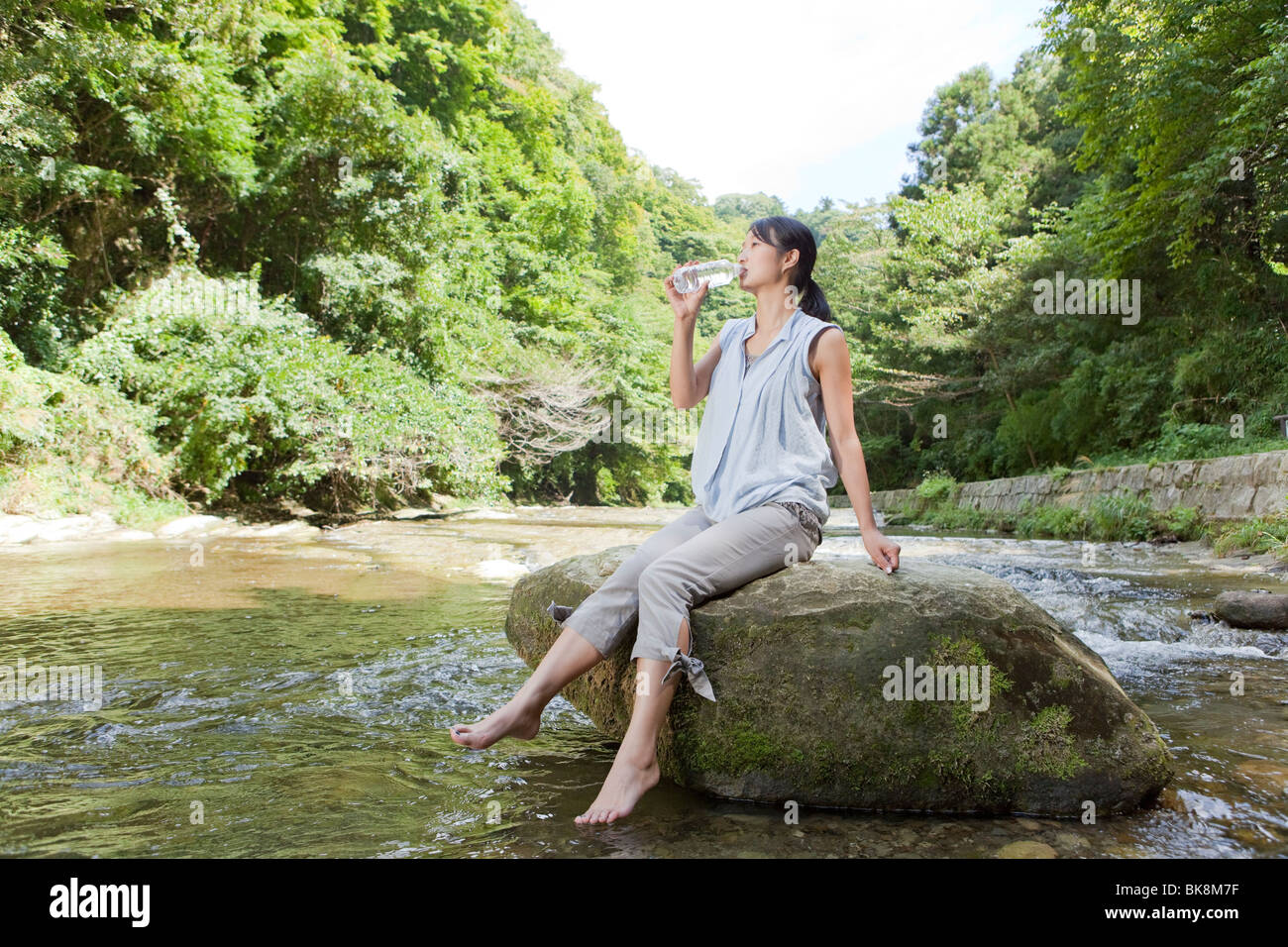Young Woman Drinking Water at River Stock Photo - Alamy