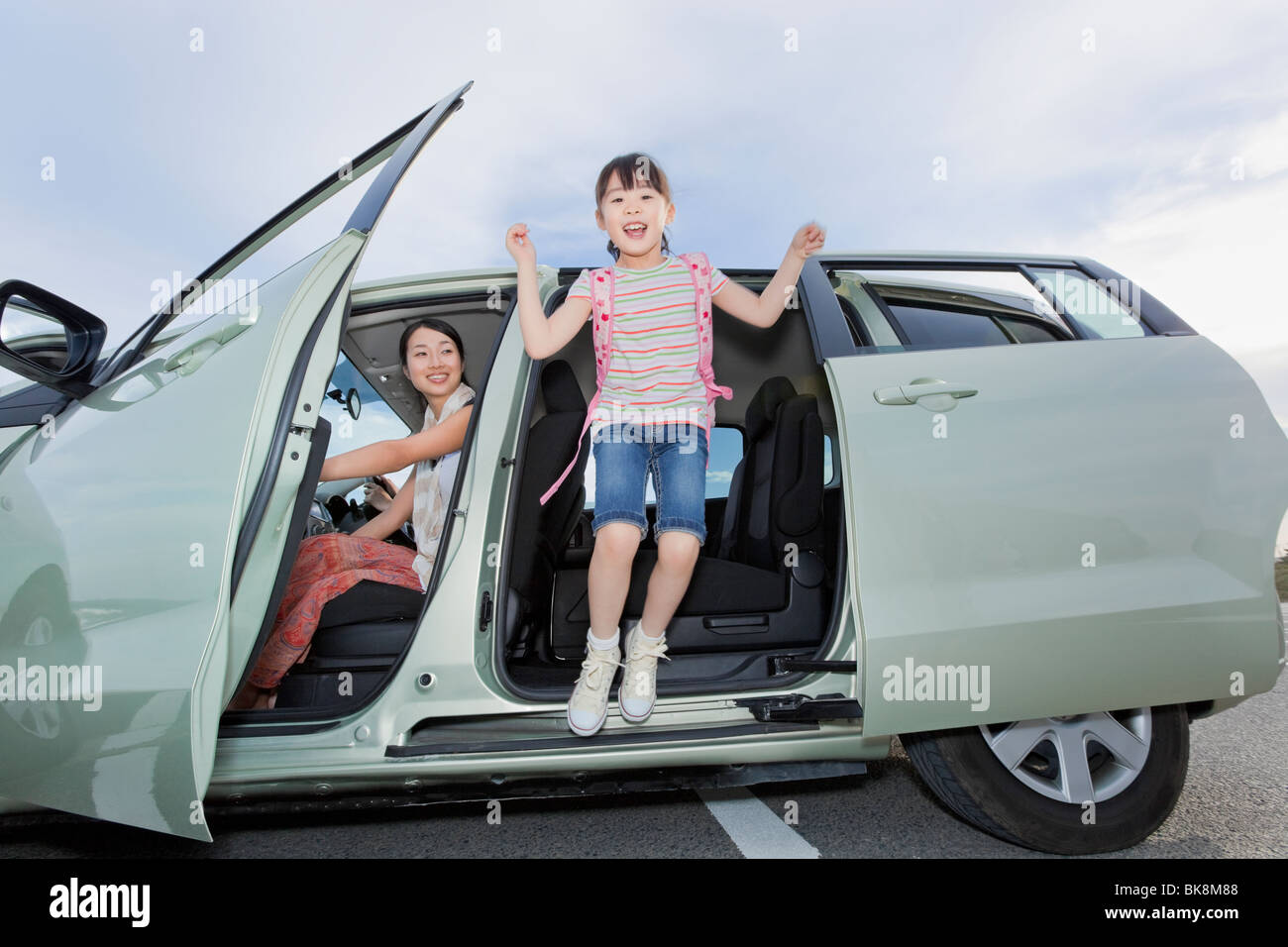 Girl Jumping Out of a Car Stock Photo - Alamy