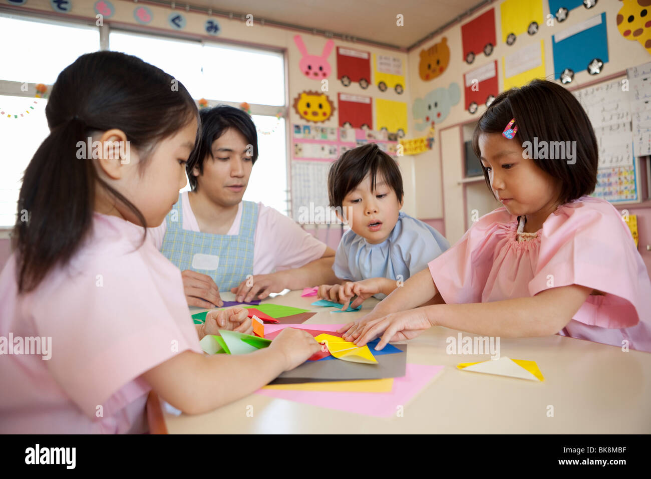 Kindergarten Teacher and Children Playing Origami Stock Photo - Alamy
