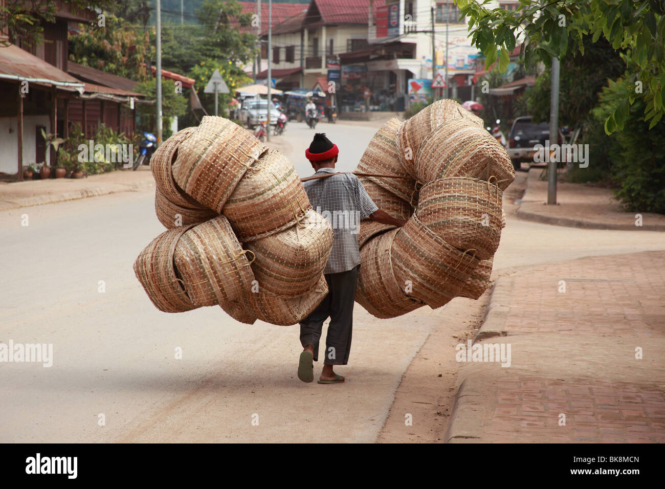 Old man carrying basket, seen in Luang Prabang Laos Stock Photo - Alamy