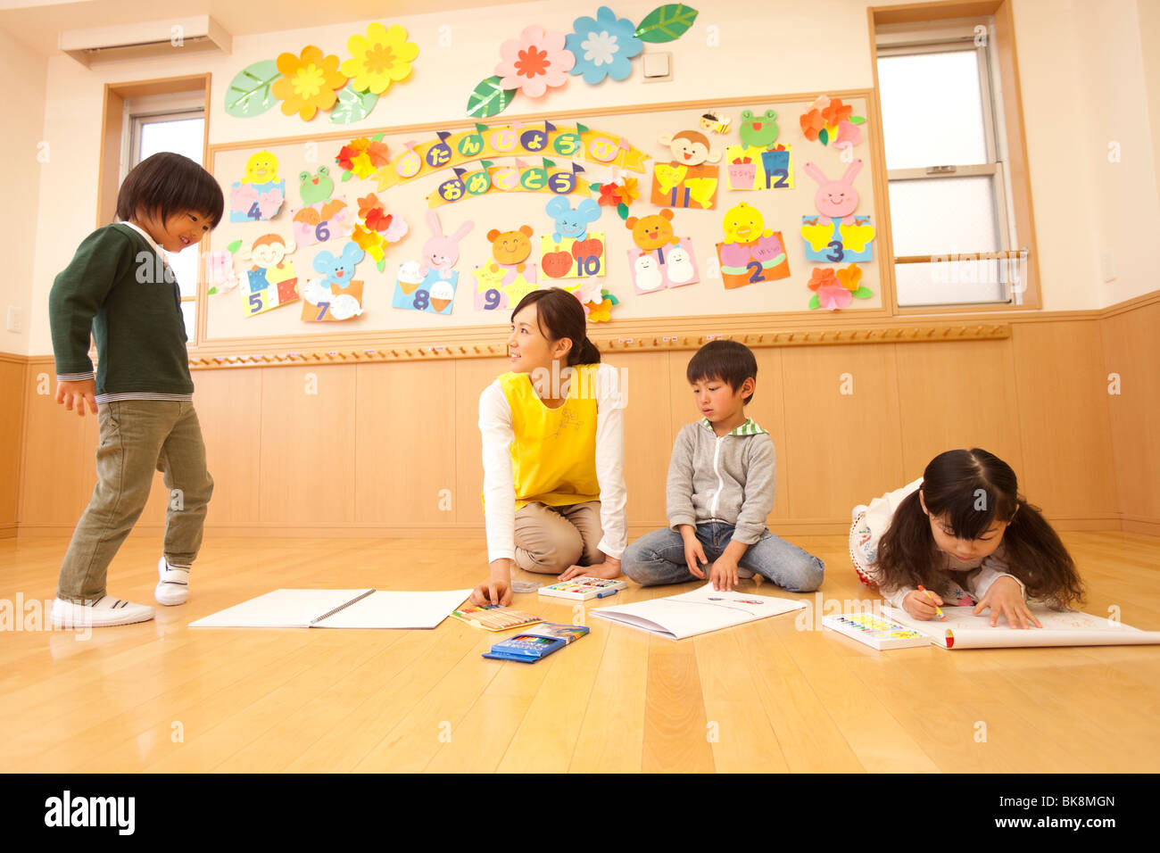 Nursery Teacher and Children Playing in a Room Stock Photo - Alamy