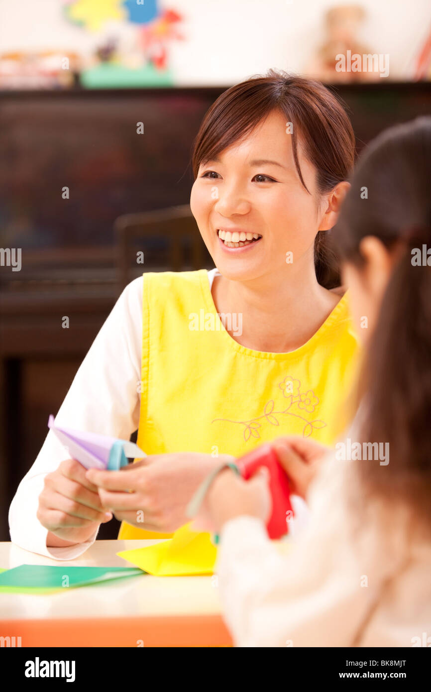 Nursery Teacher Teaching Origami Stock Photo - Alamy