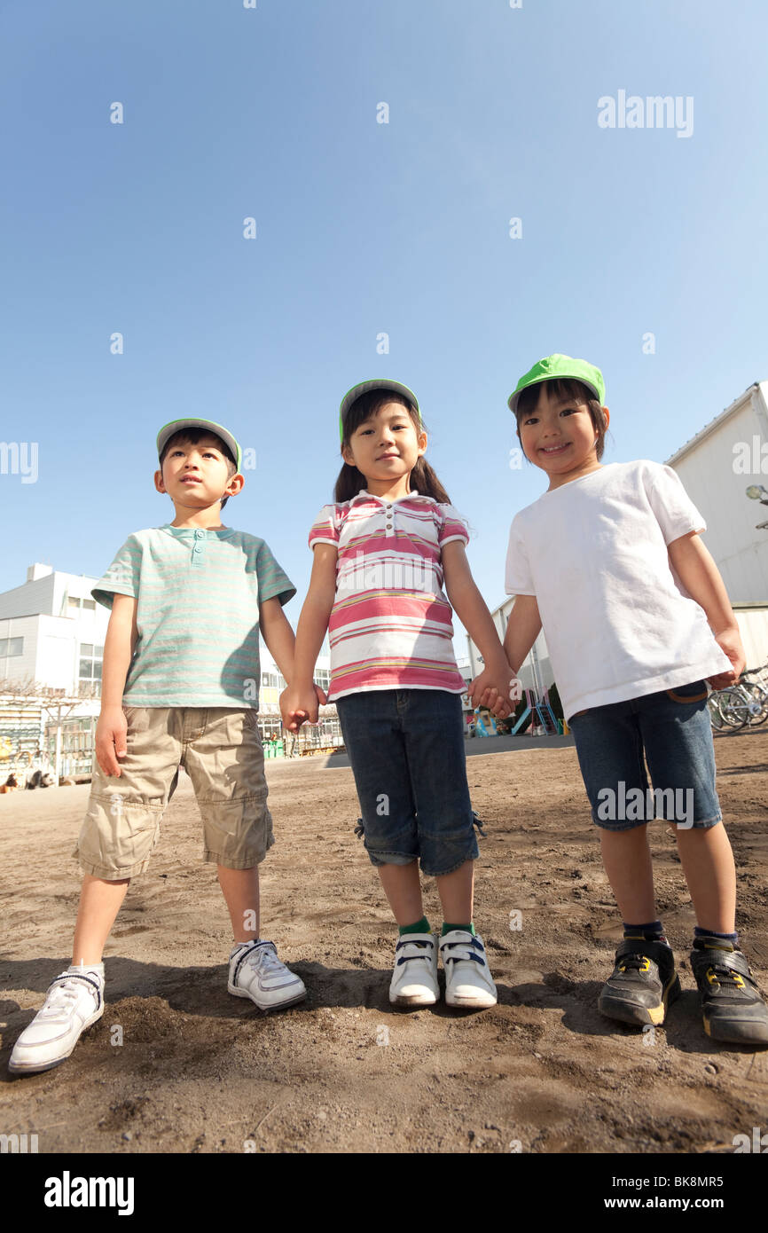 Three Children Standing at Playground Stock Photo - Alamy