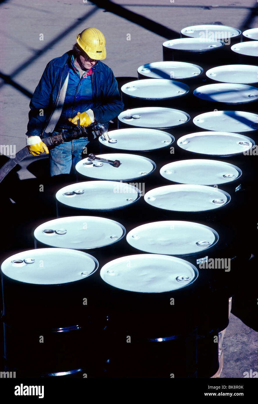 Worker filling barrels at a distributor of solvents, chemicals and ...