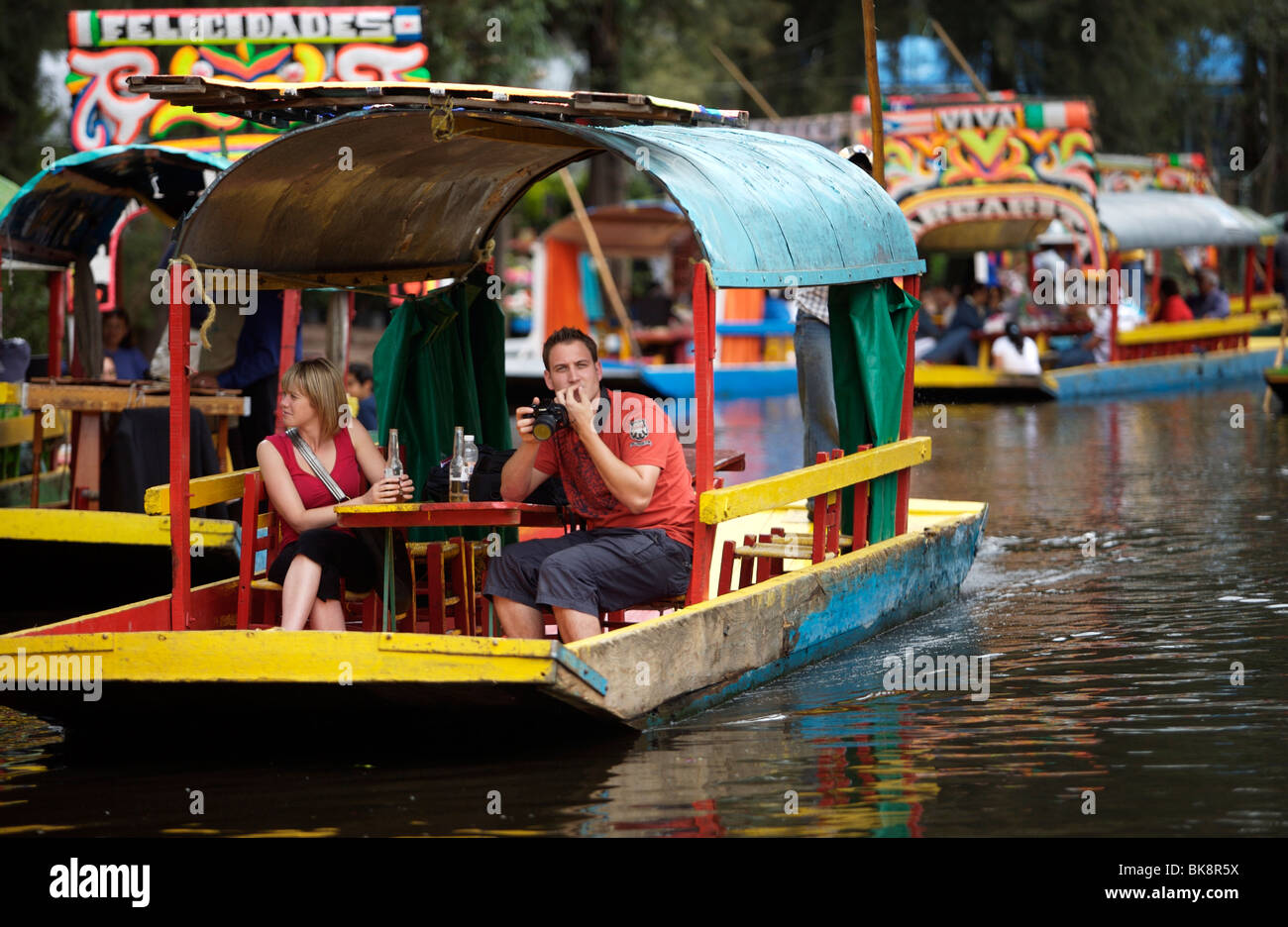 Tourists ride in a boat through the water canals of Xochimilco on the ...