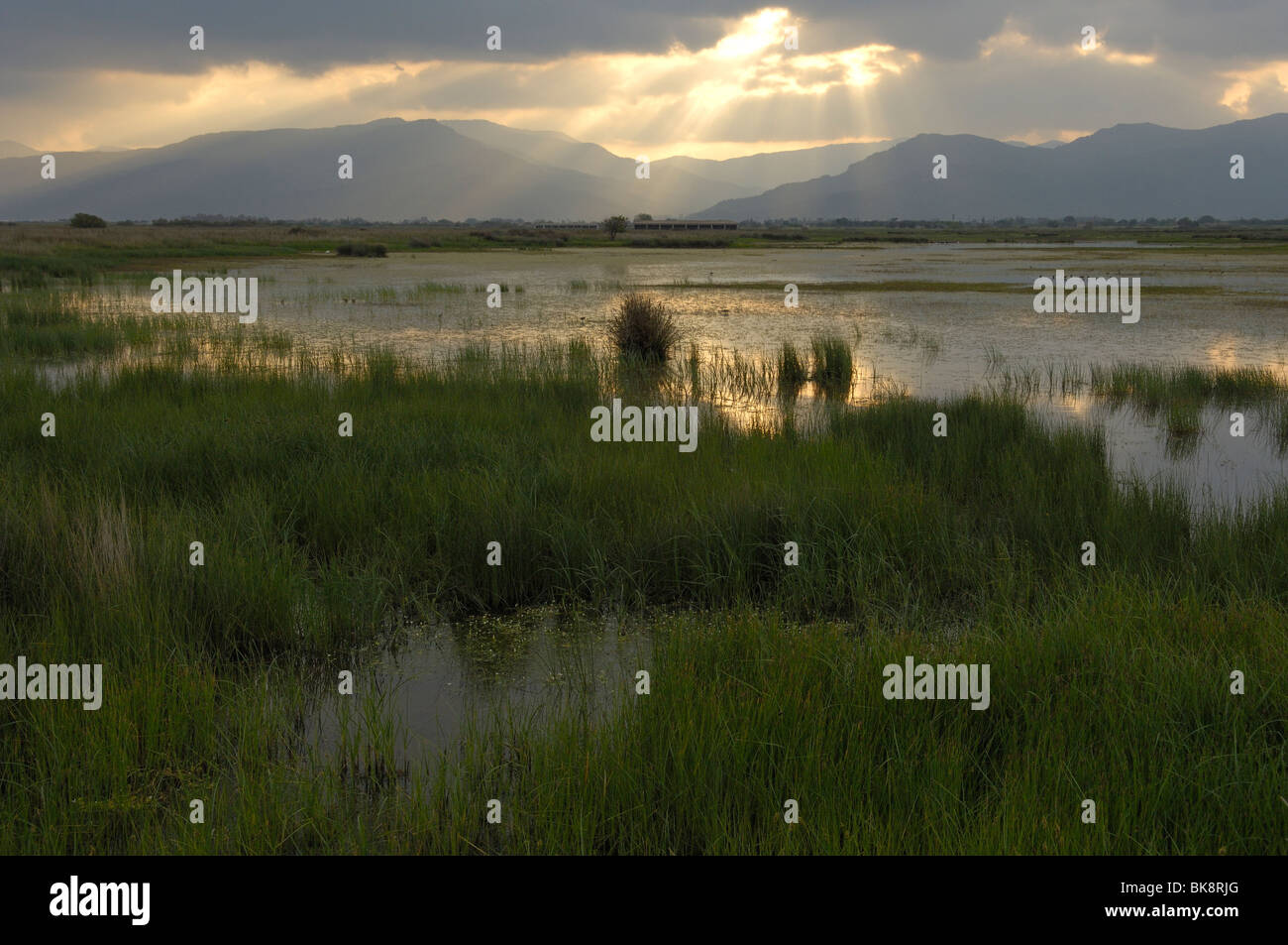 Lake at Salt Pans with backlight in evening and mountains of Skala ...