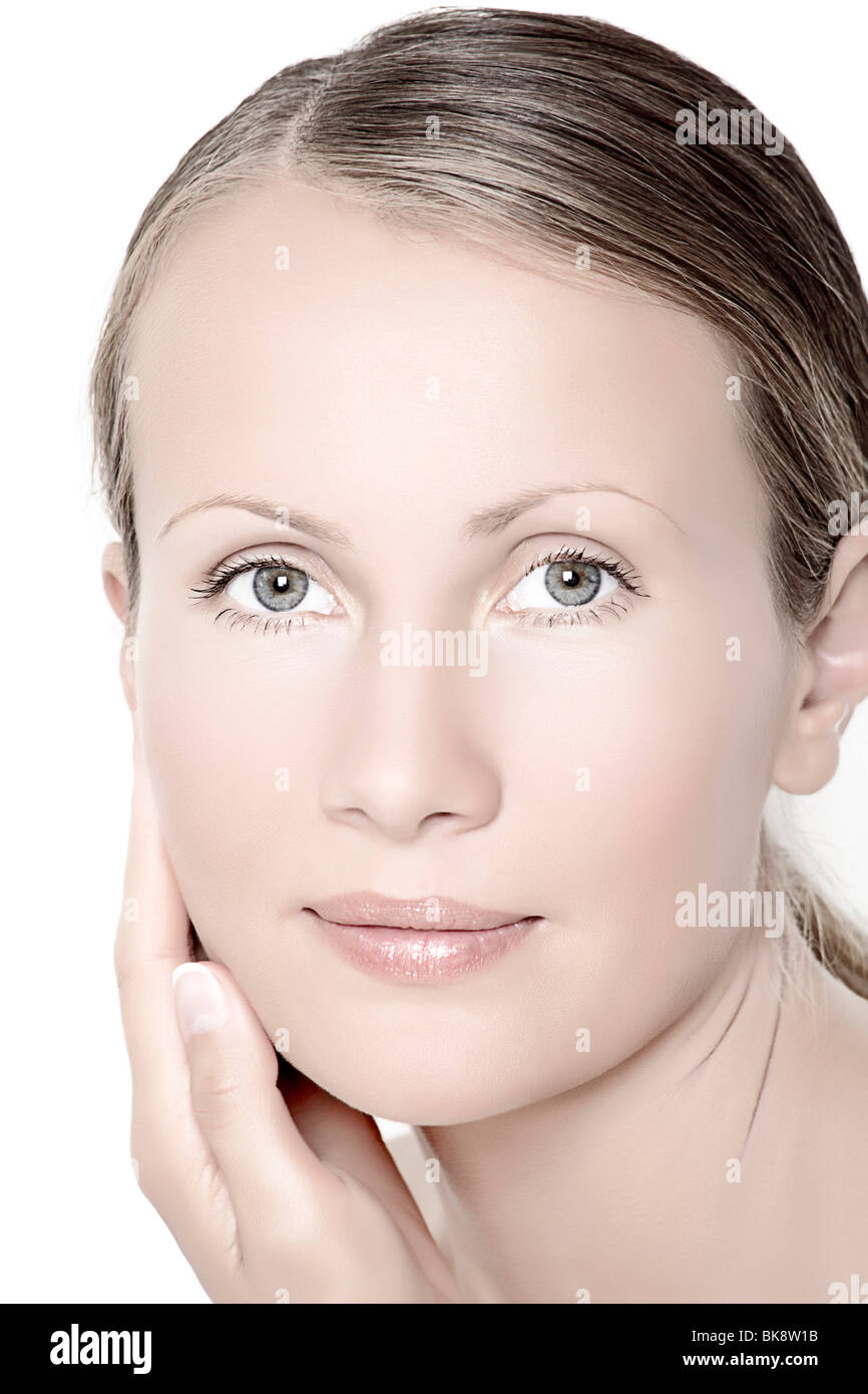 Young woman touching her cheek with her hand Stock Photo - Alamy