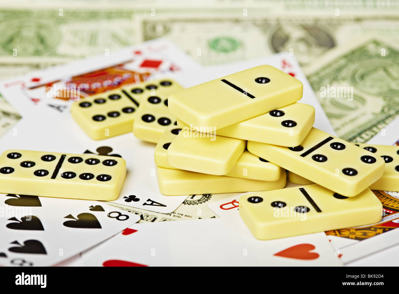 A handful of dominoes on a playing cards and money Stock Photo - Alamy
